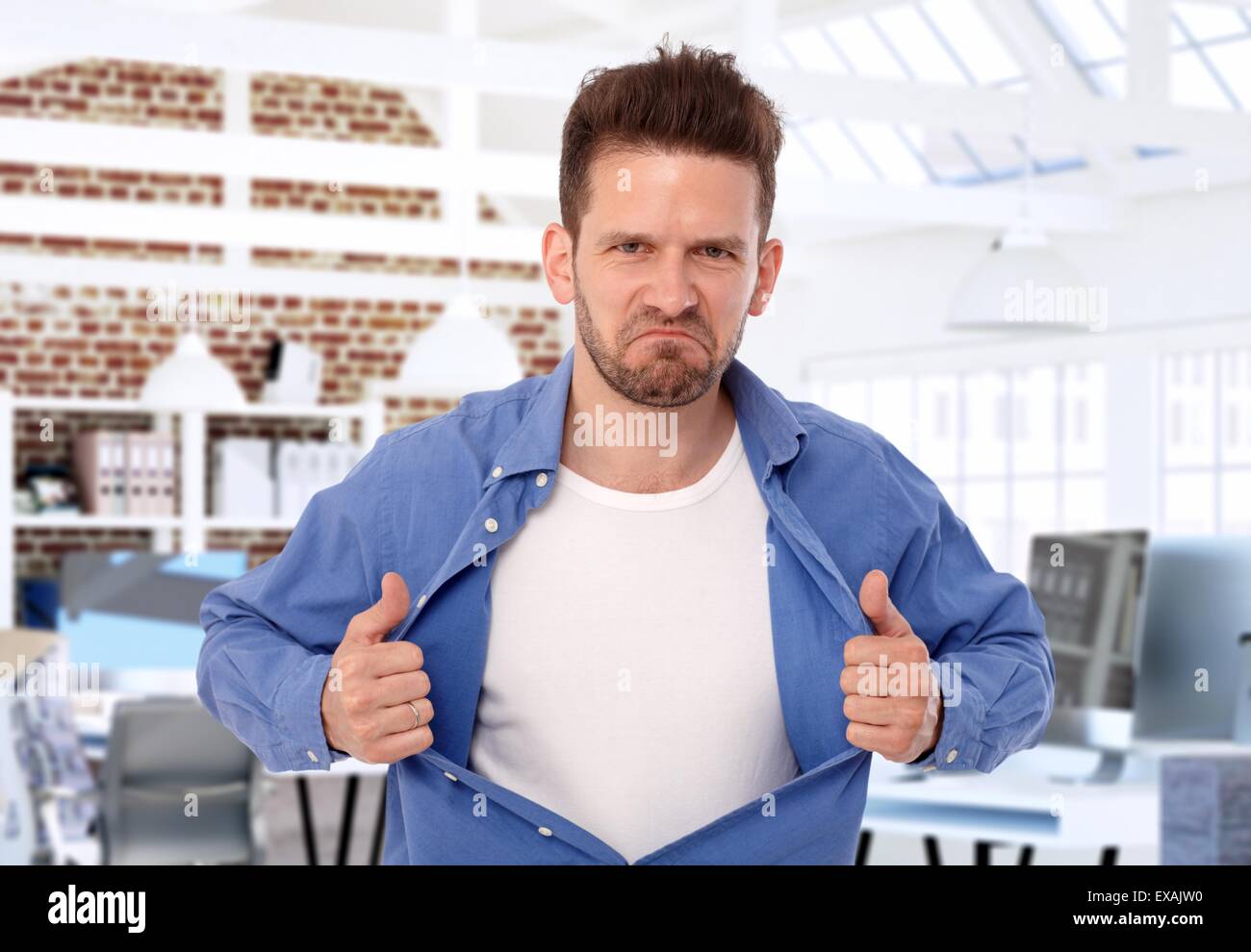 Aggressive man tearing shirt apart on his chest, looking wild Stock ...