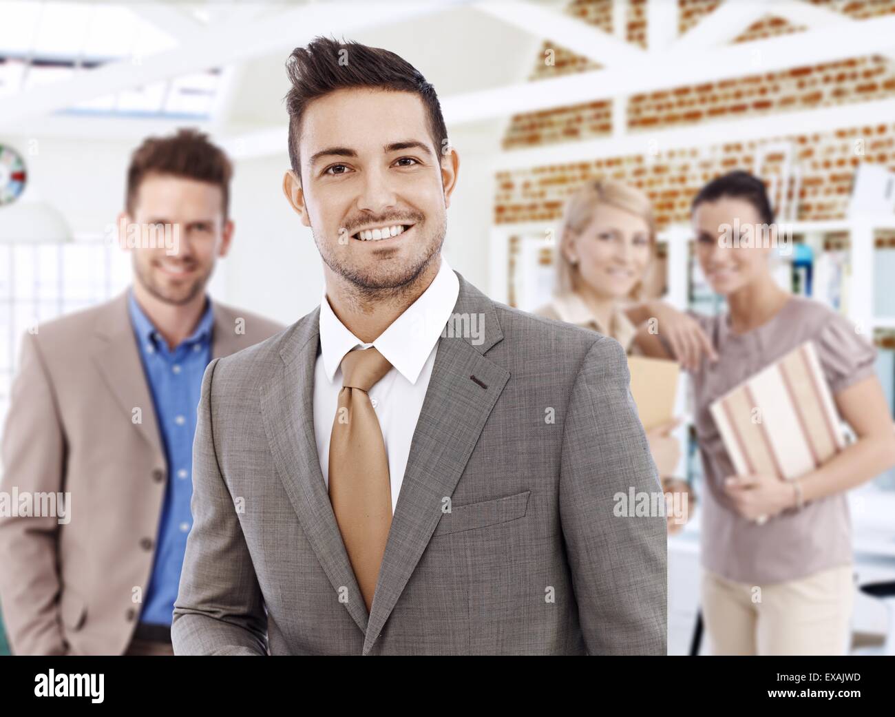 Portrait of successful young businessman, smiling, looking at camera ...