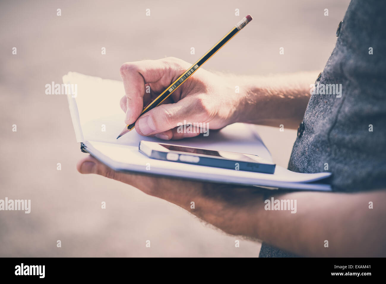 close up hands man writing on diary and smartphone outdoor Stock Photo ...