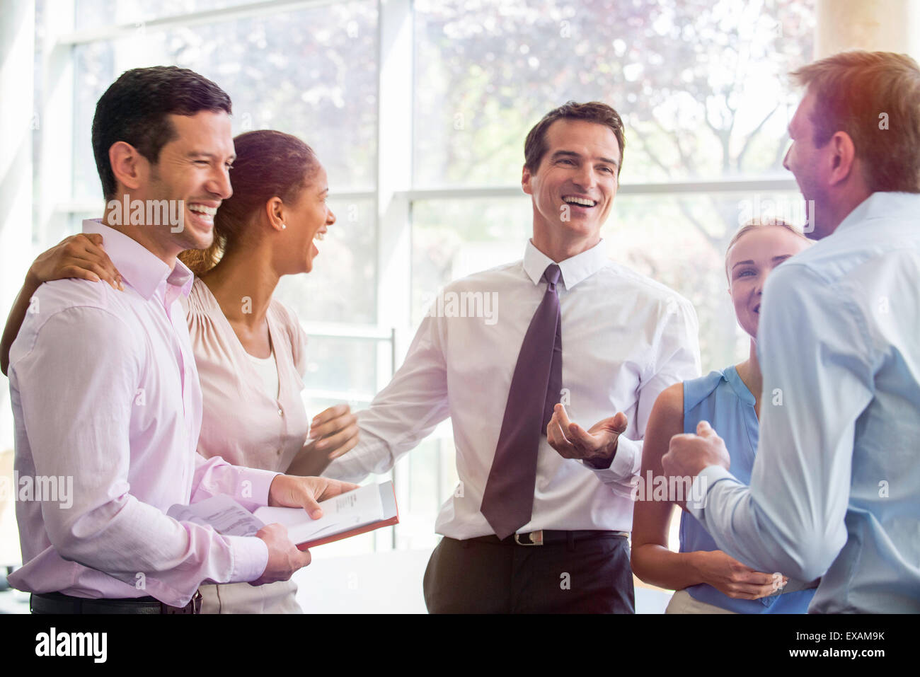 Colleagues having laugh together in office Stock Photo - Alamy