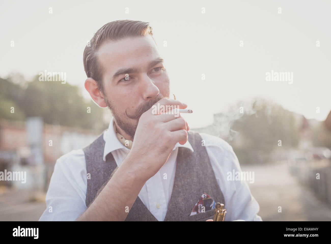 handsome big moustache hipster man smoking cigarette in the city Stock ...