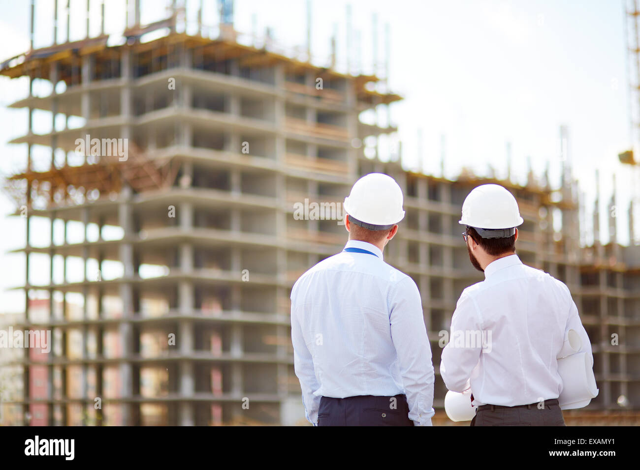 Male architects standing in front of new construction Stock Photo - Alamy