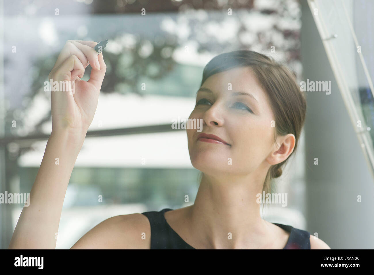 Woman preparing to write on window with marker Stock Photo - Alamy