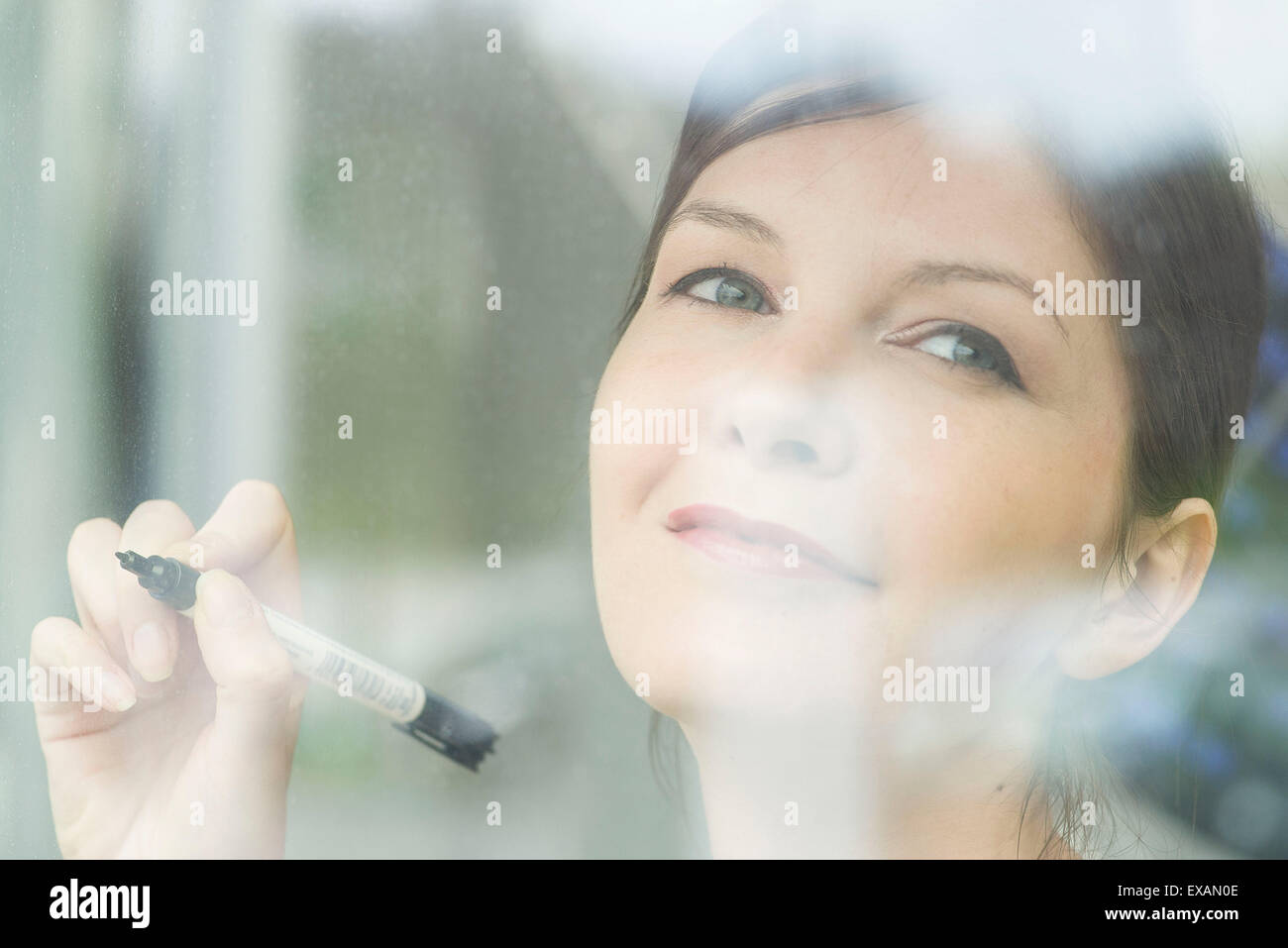 Woman preparing to write on window with marker Stock Photo - Alamy