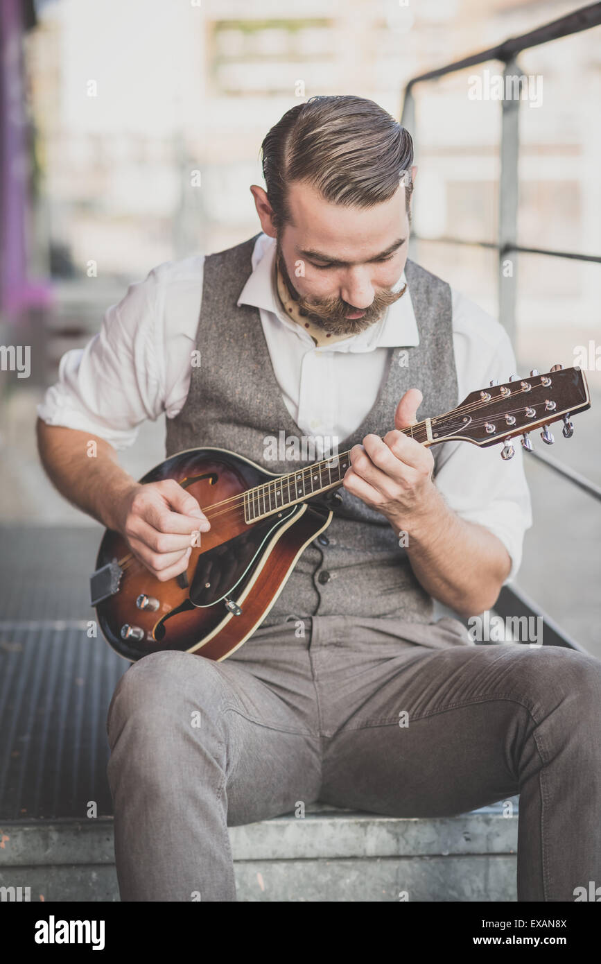 handsome big moustache hipster man playing mandolin in the city Stock ...