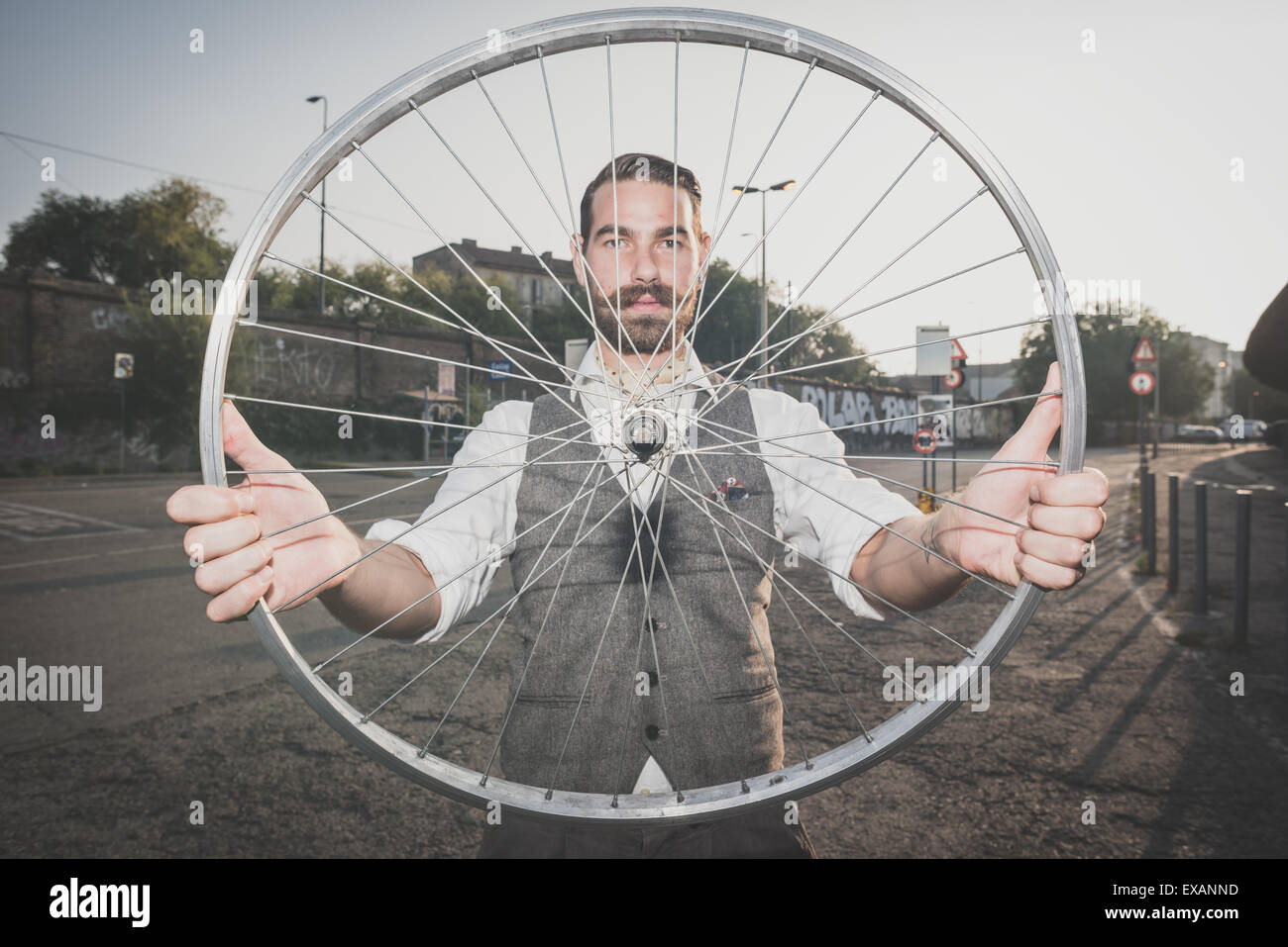 handsome big moustache hipster man holding old bicycle wheel in the ...