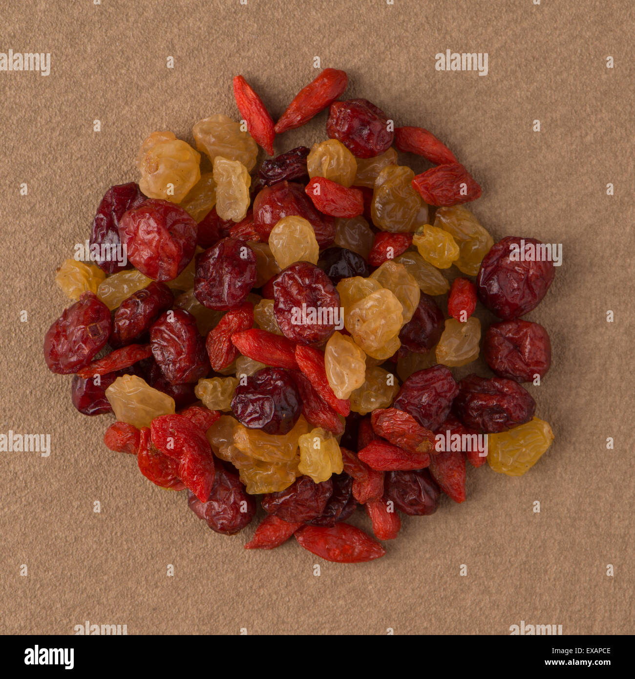 Top view of circle of mixed dried fruits against brown vinyl background ...