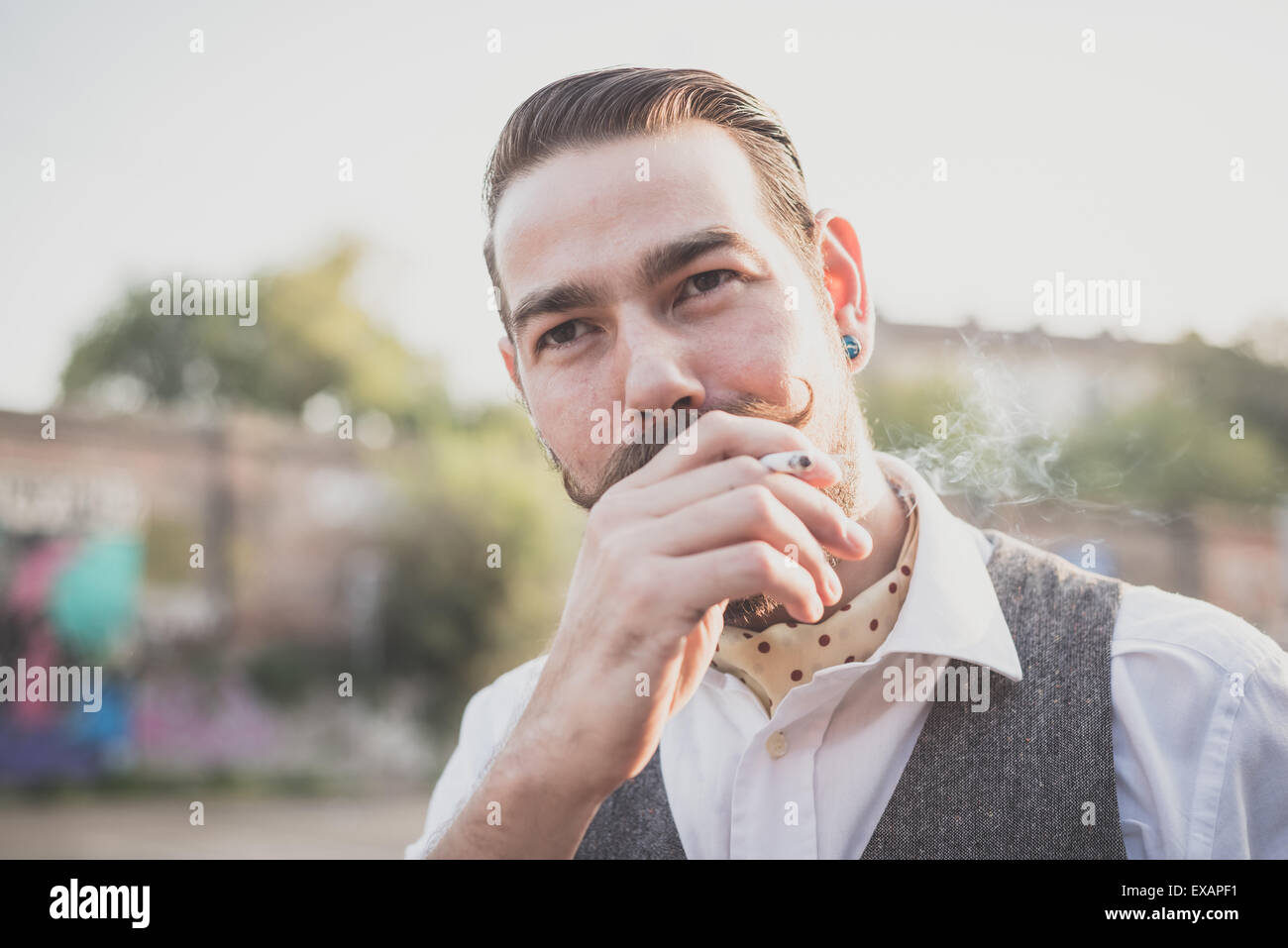 handsome big moustache hipster man smoking cigarette in the city Stock ...