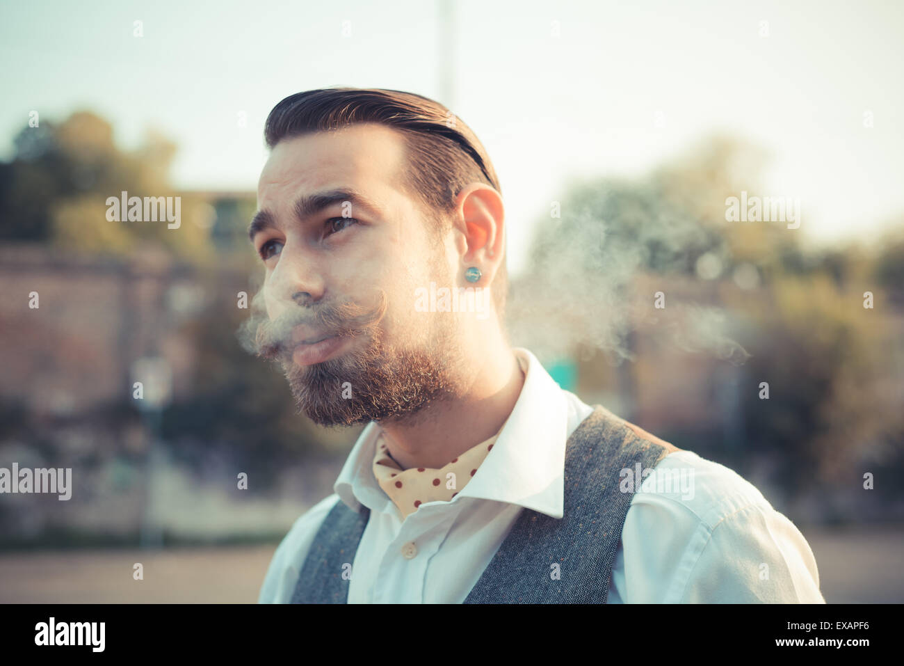 handsome big moustache hipster man smoking cigarette in the city Stock ...