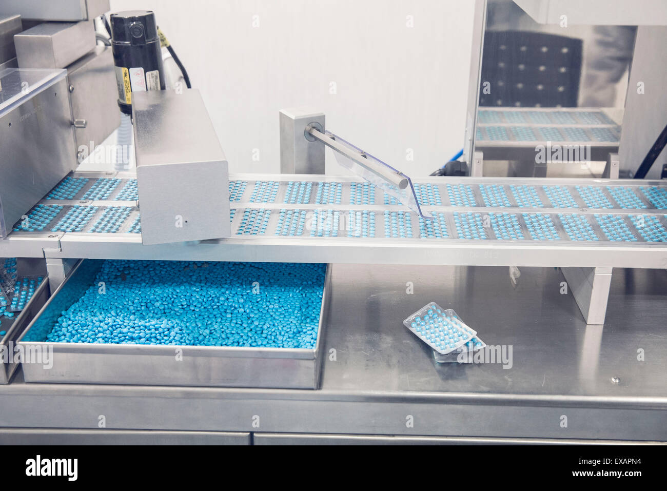 Tablet trays on conveyor belt entering blisterpack sealing machine ...