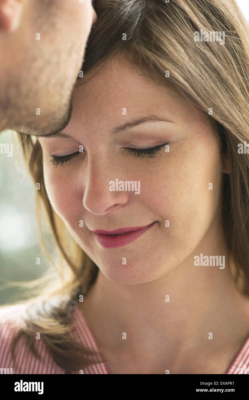Man kissing woman's forehead, cropped Stock Photo - Alamy