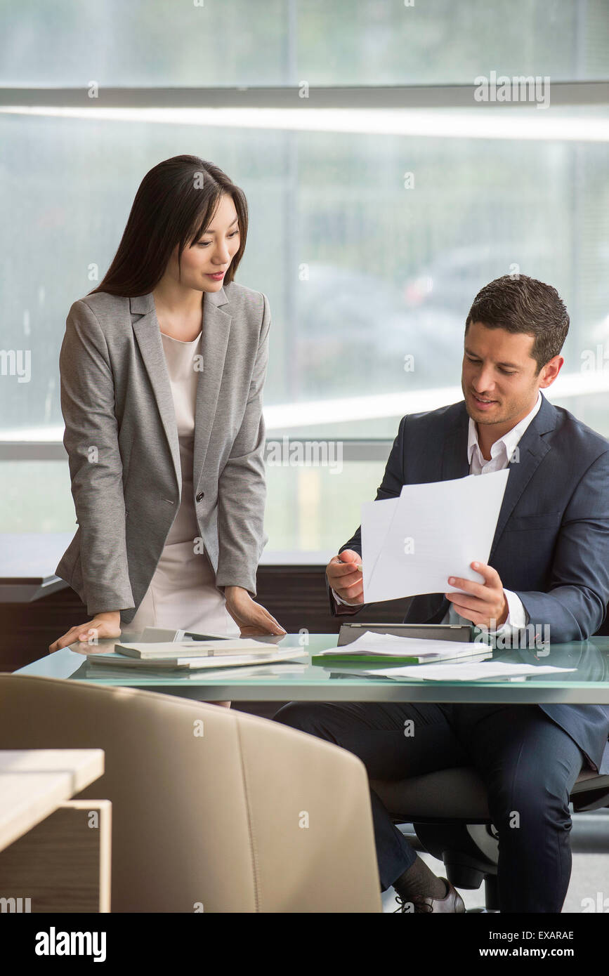 Manager reviewing document with assistant Stock Photo - Alamy