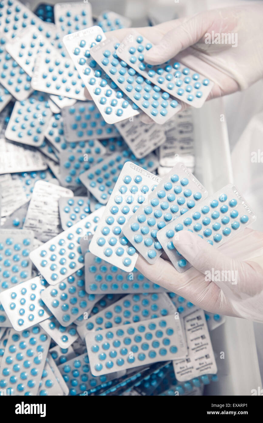 Worker inspecting pill packets Stock Photo - Alamy