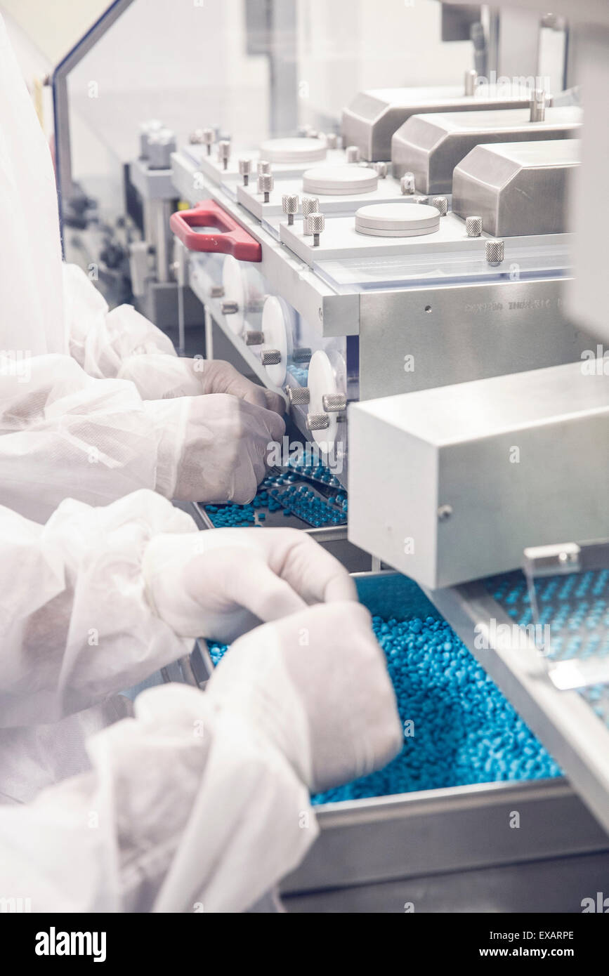 Worker monitoring pill packaging machinery Stock Photo - Alamy