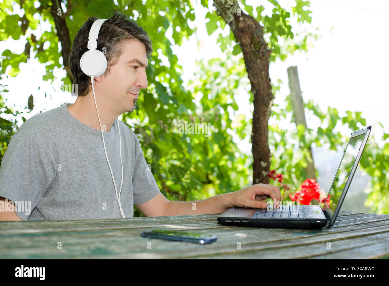 man sitting outdoor working with a laptop Stock Photo - Alamy