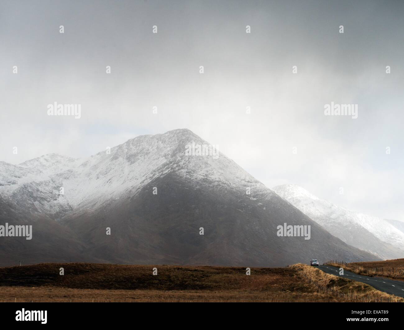 Driving through the Lough Inagh Valley with snow capped Maam Turk ...