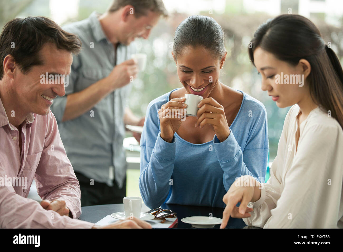 Friends enjoying coffee break Stock Photo - Alamy