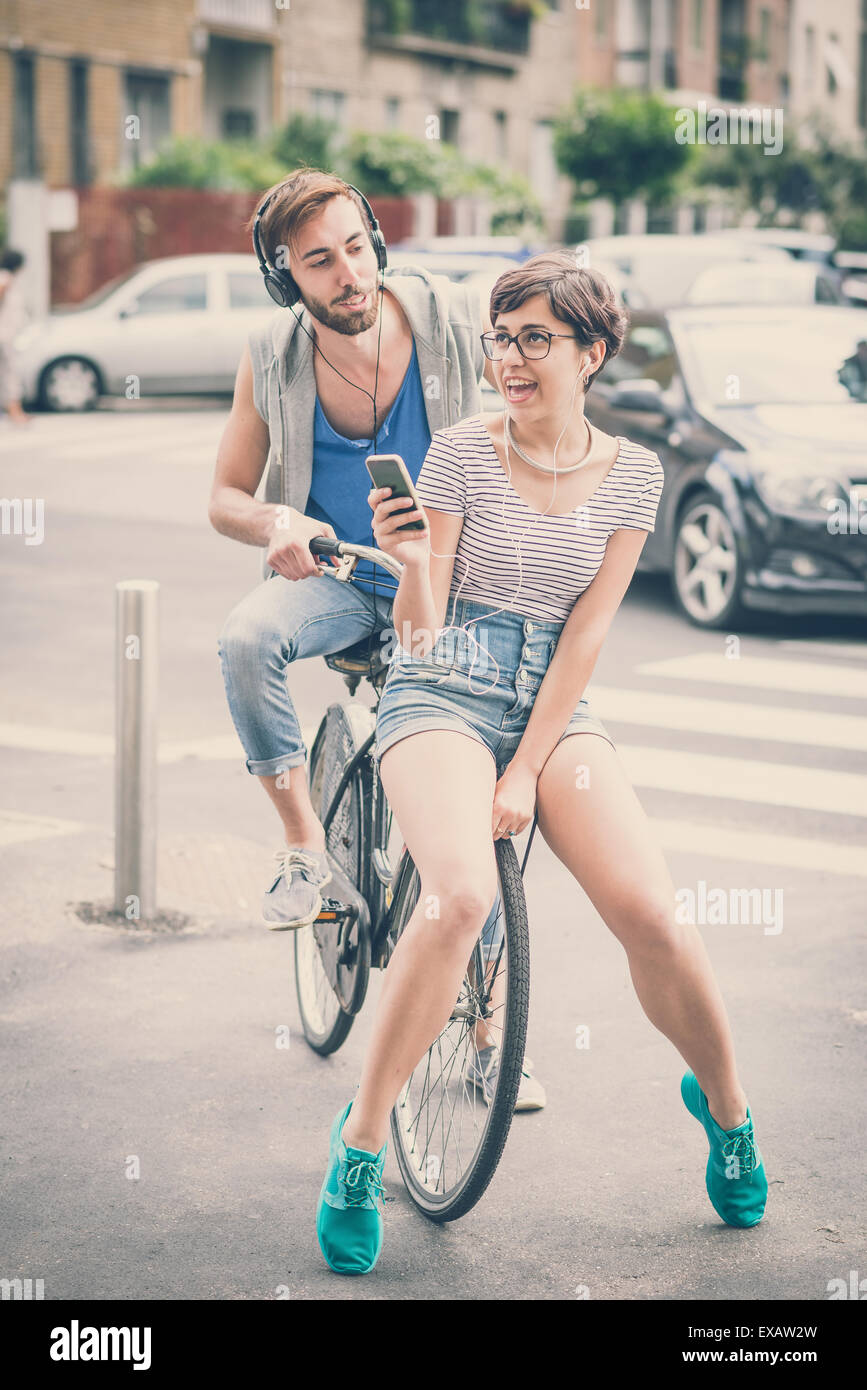 couple of friends young man and woman riding bike in the city Stock ...