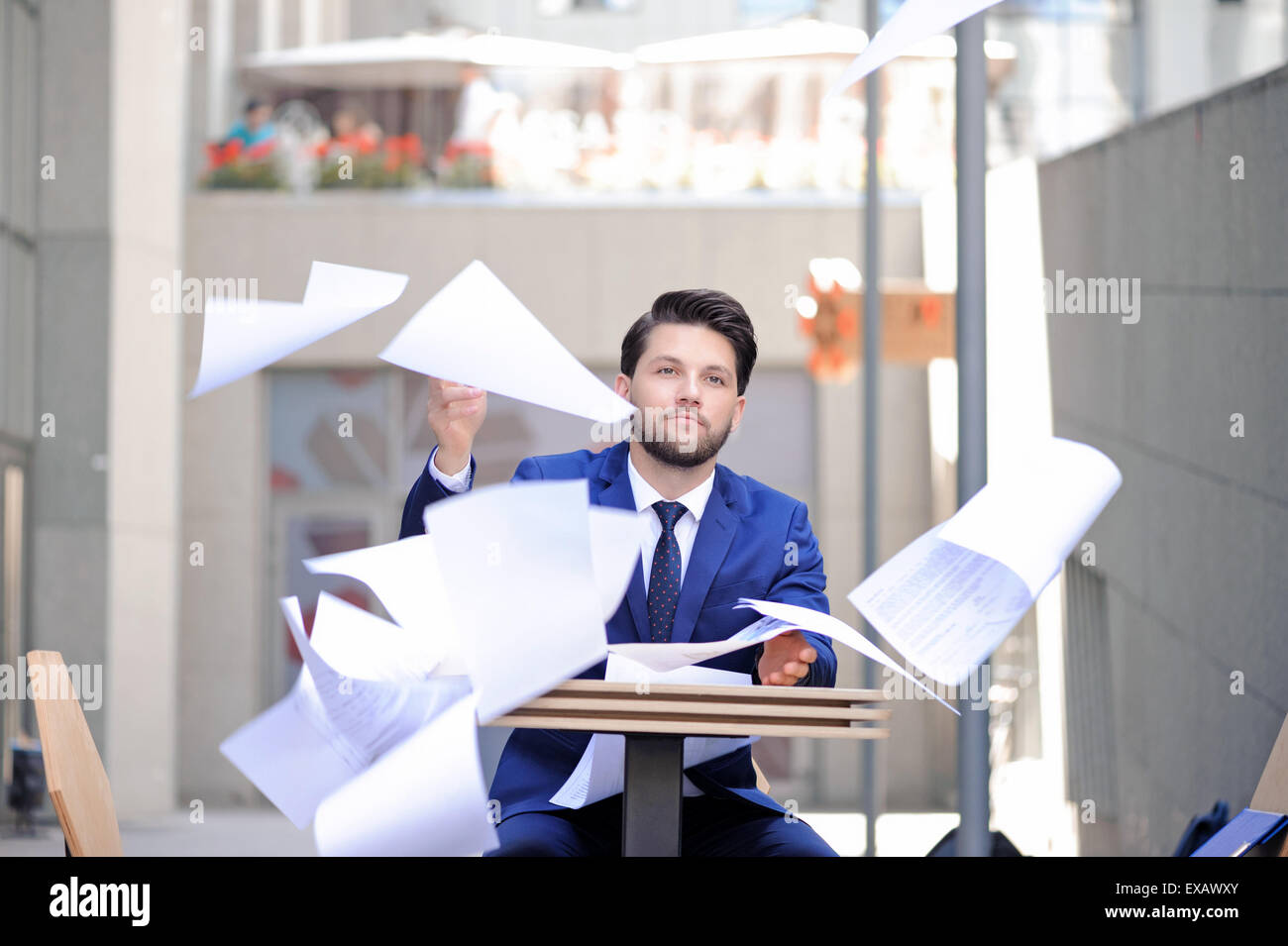 Serious man throwing papers out Stock Photo - Alamy