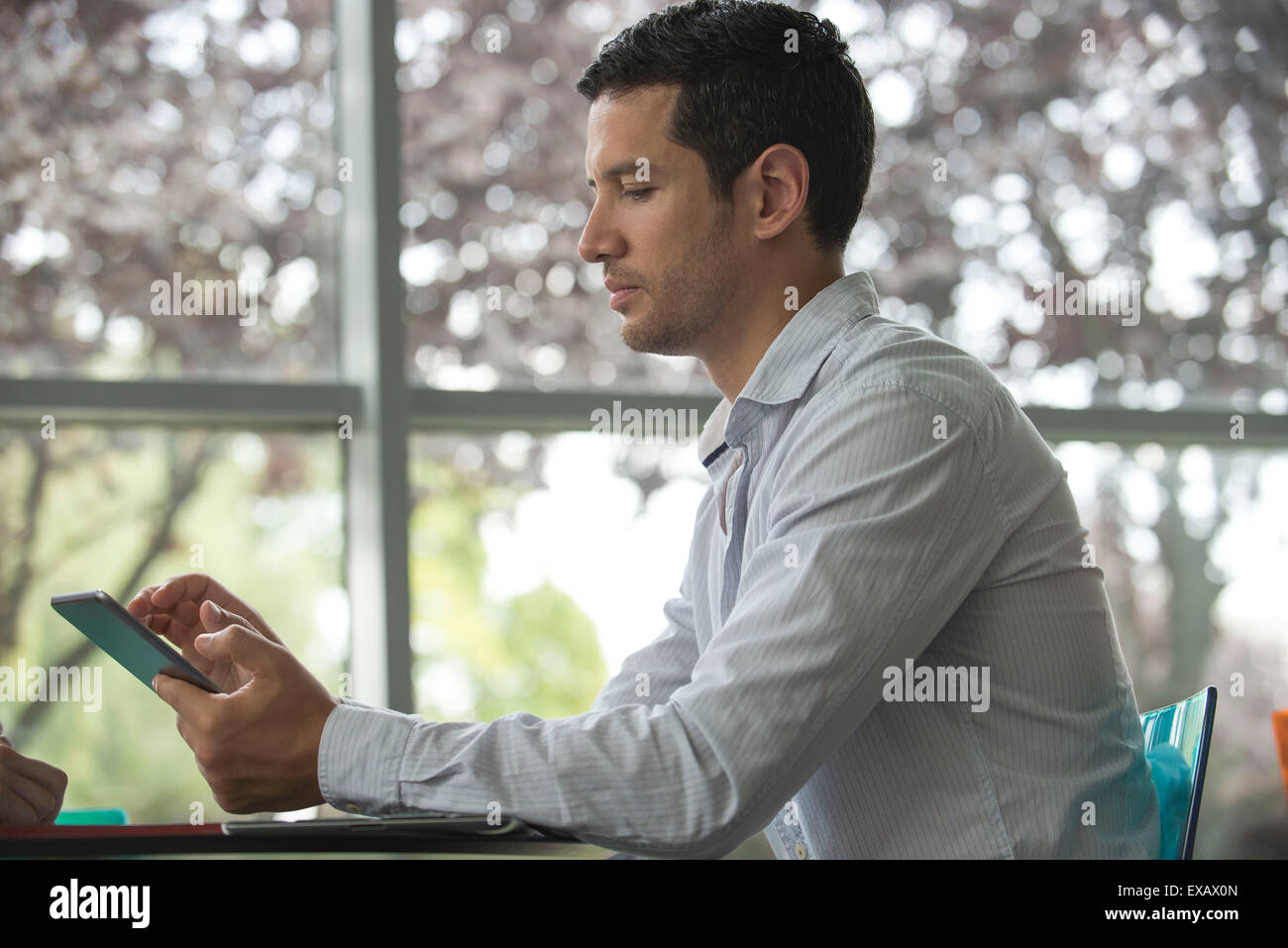 Man using digital tablet, side view Stock Photo - Alamy