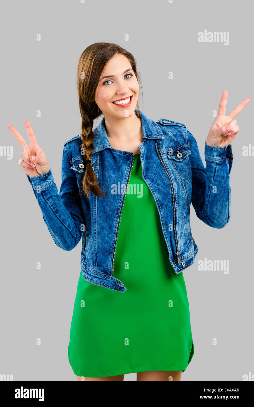 Portrait of a beautiful woman with fingers up, isolated over grey ...