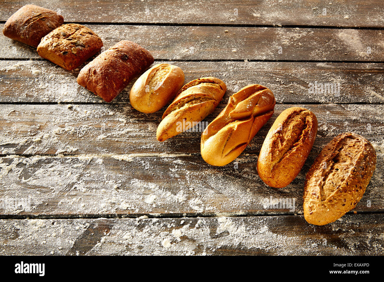 Breads varied in a row on rustic wood table with wheat flour Stock ...