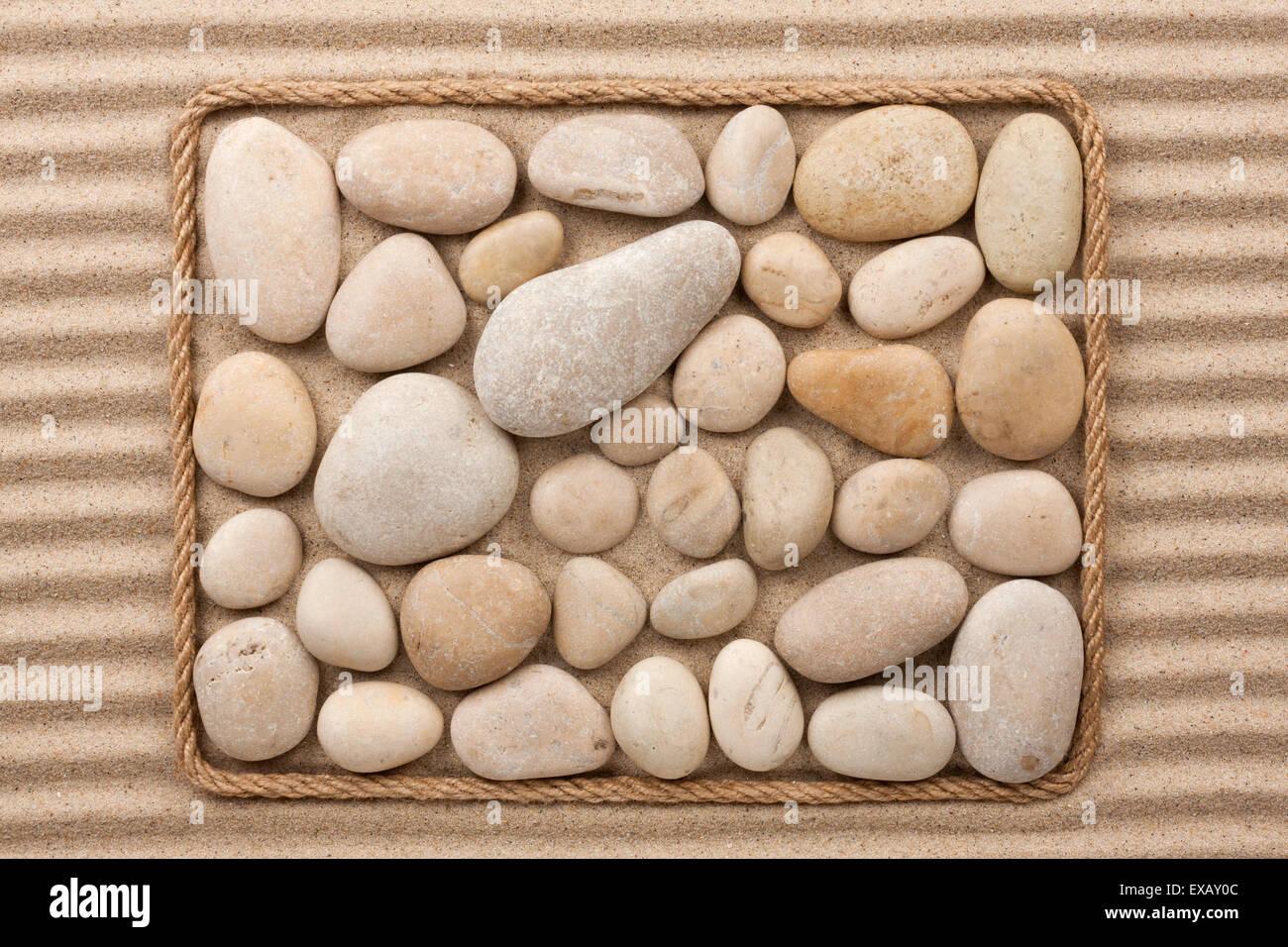 Frame made of rope with white stones on the wavy sand Stock Photo - Alamy
