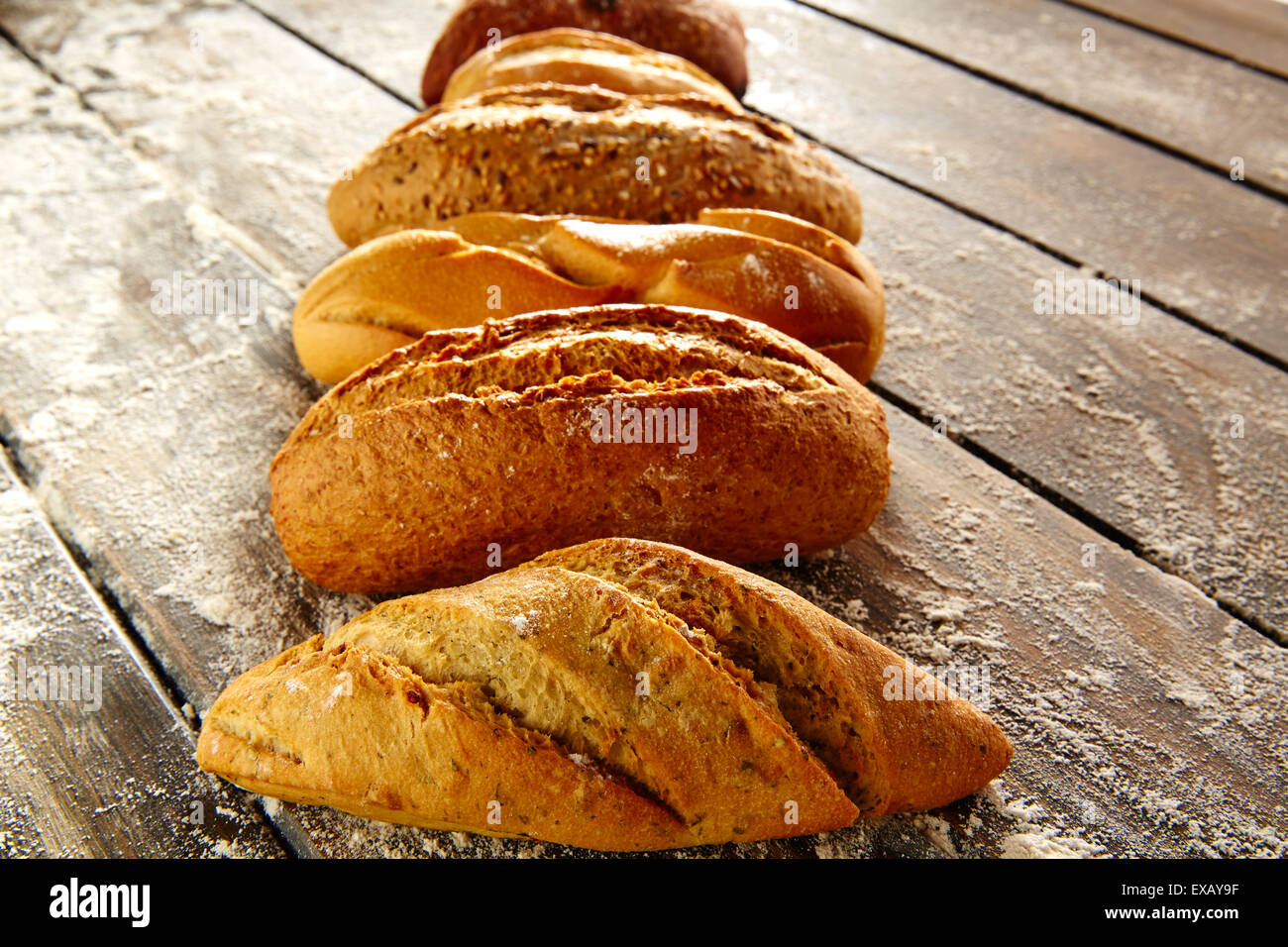 Breads varied in a row on rustic wood table with wheat flour Stock ...