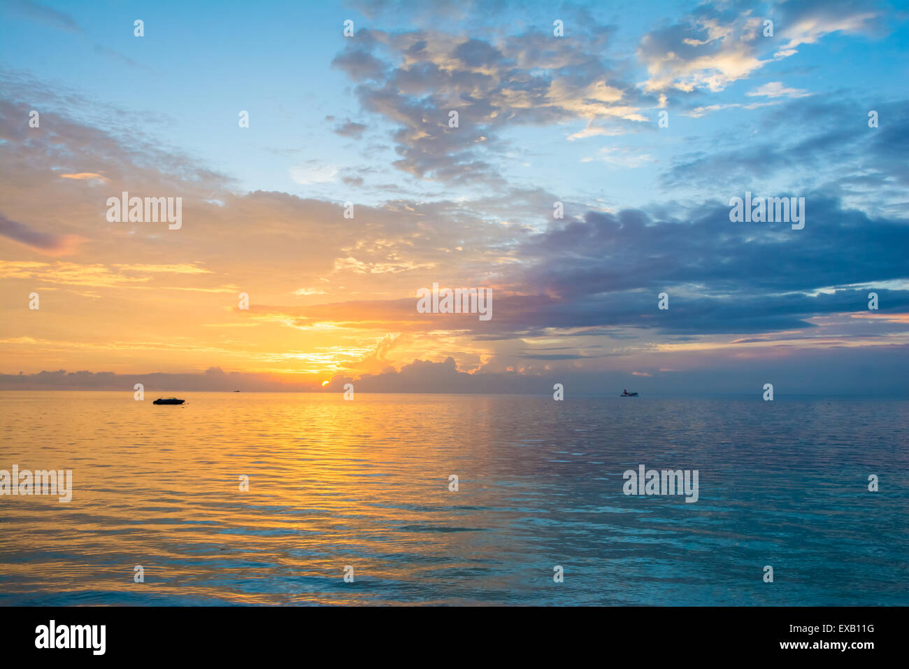 Golden sunset over a turquoise blue ocean in Maldives Stock Photo - Alamy