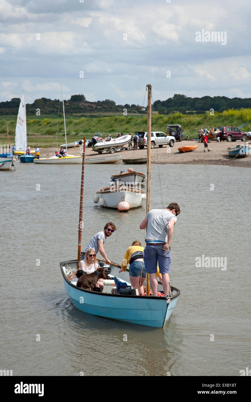 Young people setting off in small sailing boat from Morston quay ...