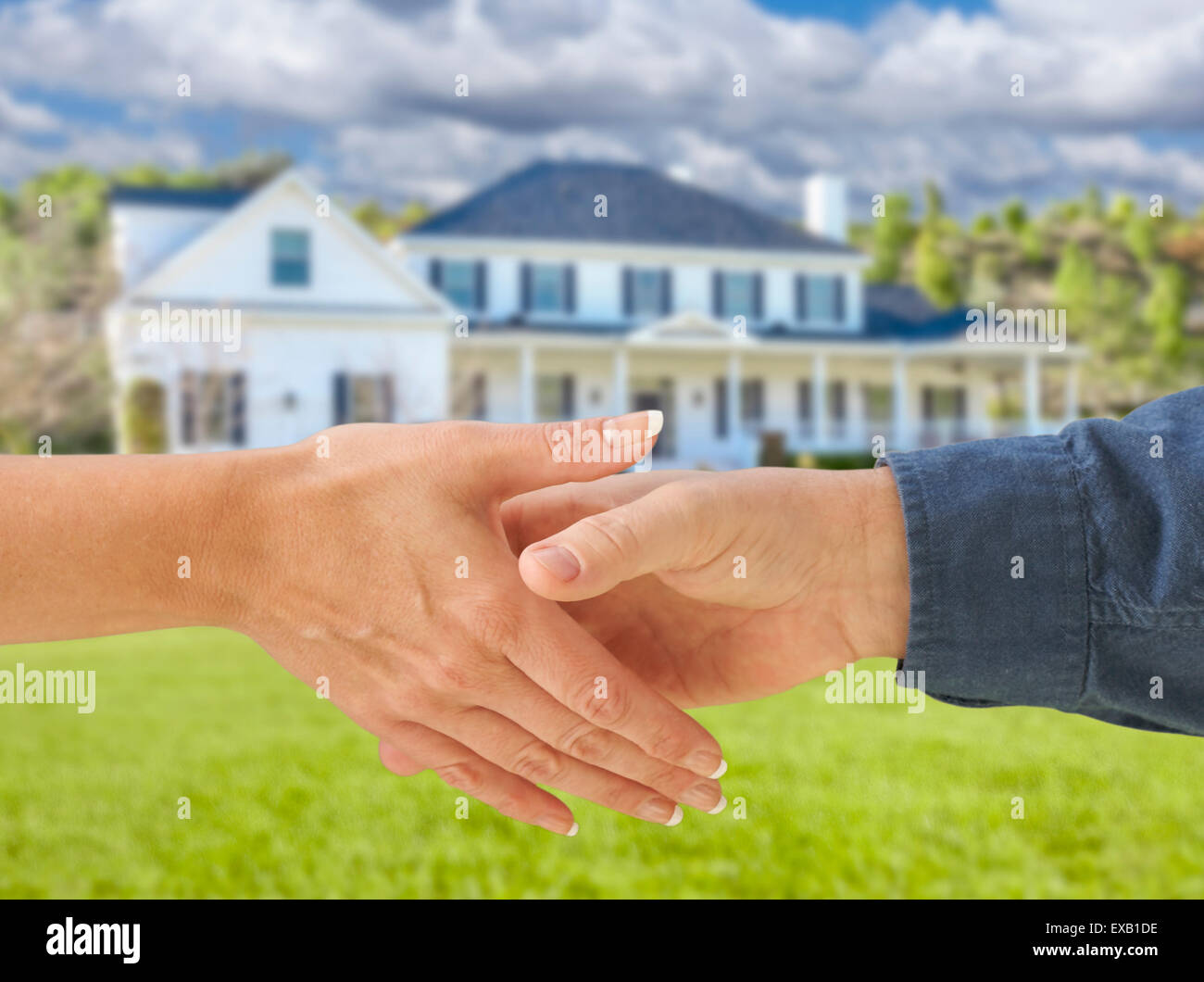 Man and Woman Shaking Hands in Front of a Beautiful New House Stock ...