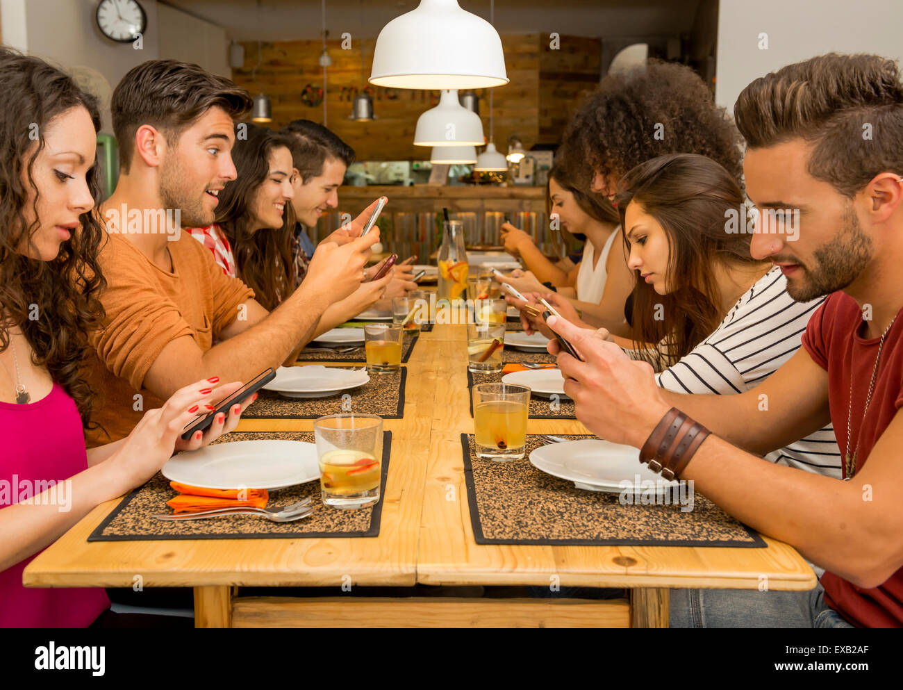 Group of friends at a restaurant with all people on the table occupied ...