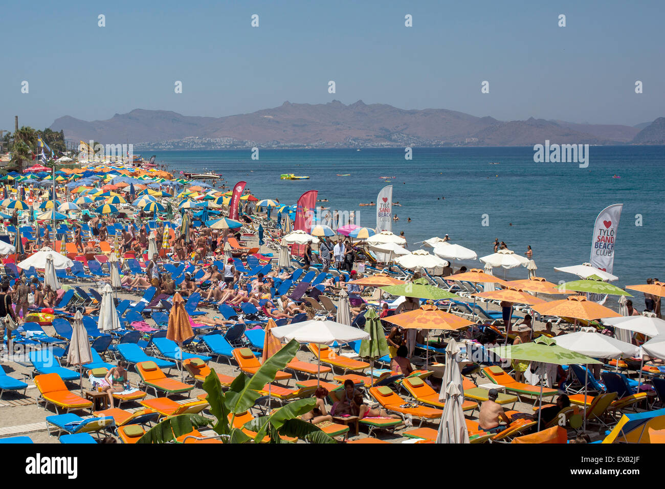 Tourists enjoy the sun at a beach near Kos town, on Kos island, Greece ...