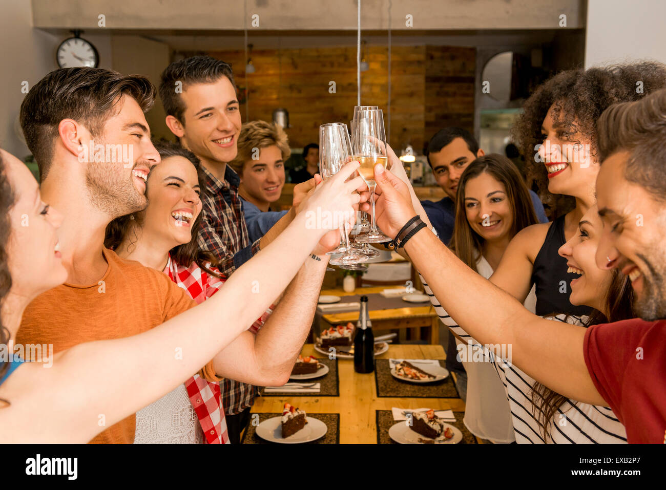 Group of friends toasting and looking happy at a restaurant Stock Photo ...