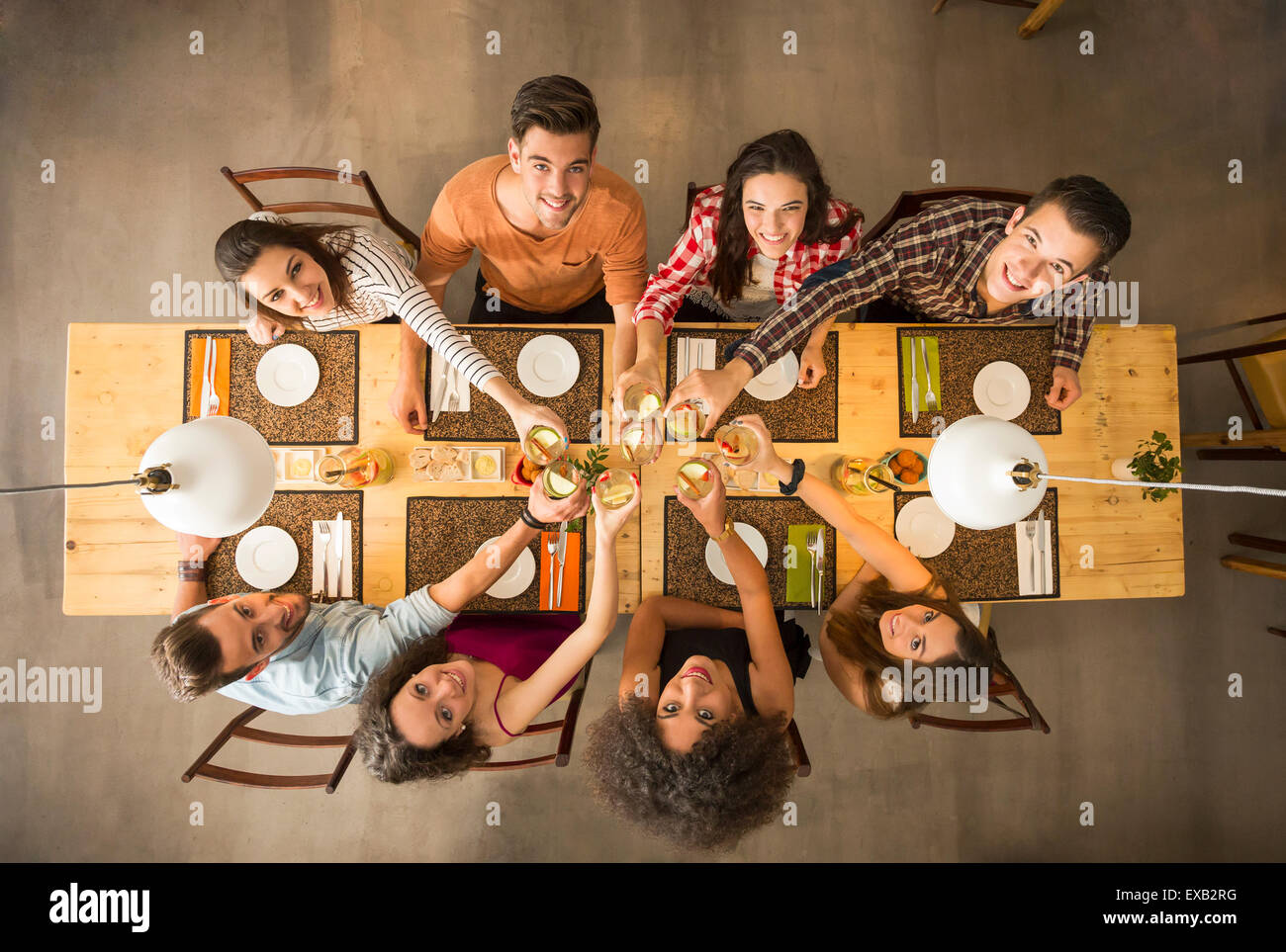 Group of people toasting and looking happy at a restaurant Stock Photo ...