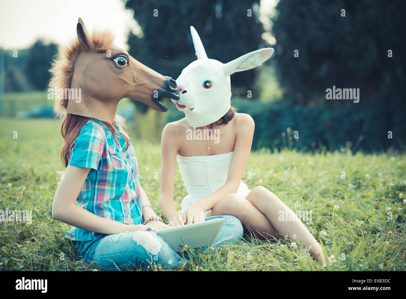 mask horse and rabbit women sisters friends using smartphone and tablet ...