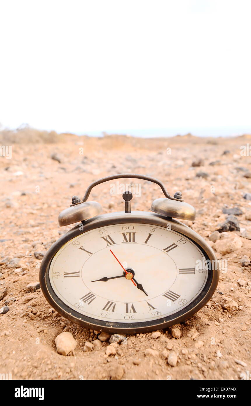 Classic Analog Clock In The Sand Stock Photo - Alamy