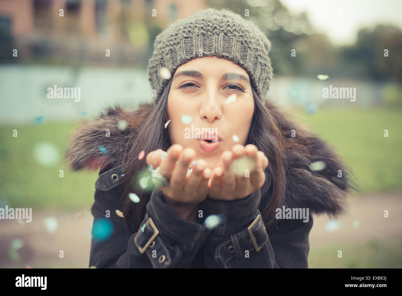young beautiful brunette woman playing with confetti carnival in the ...