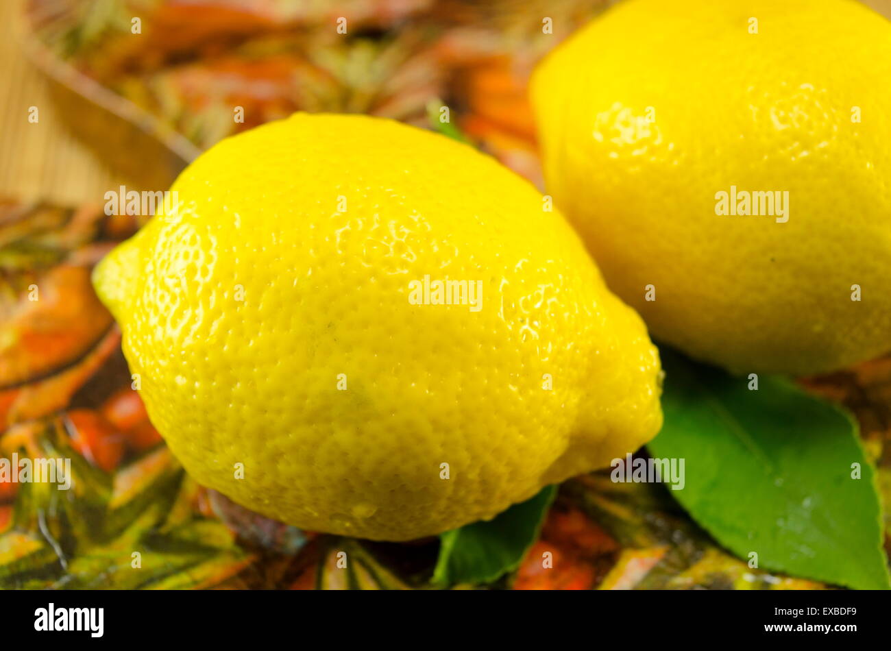 Two fresh lemons on a decoupage decorated table Stock Photo - Alamy