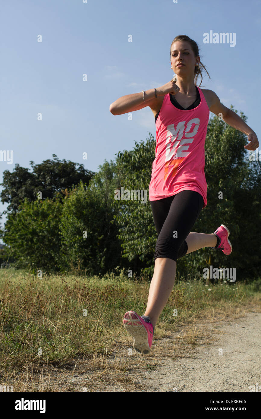 Blonde girl running at the park in the summer Stock Photo - Alamy