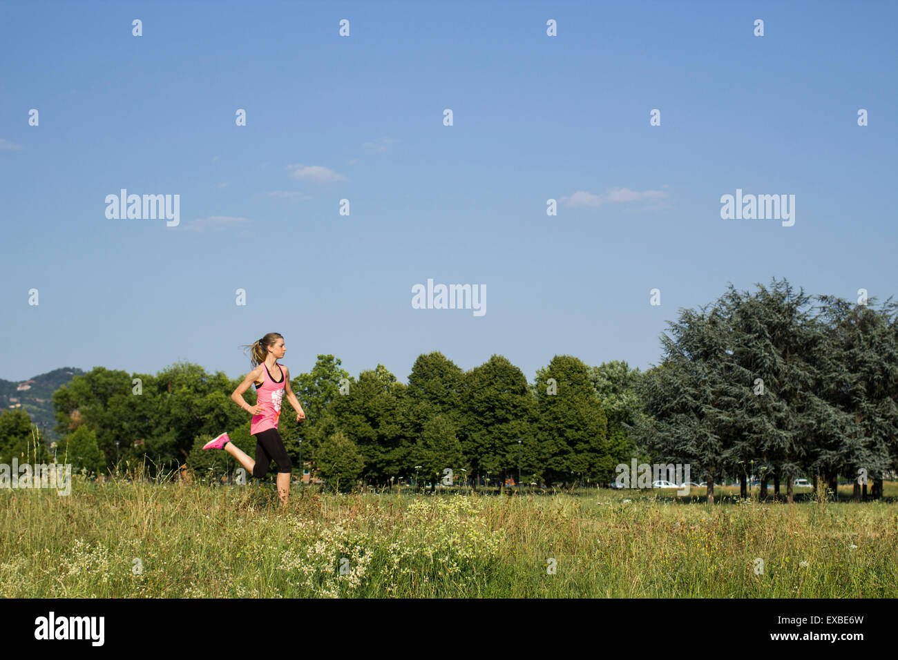 Blonde girl running at the park in the summer Stock Photo - Alamy