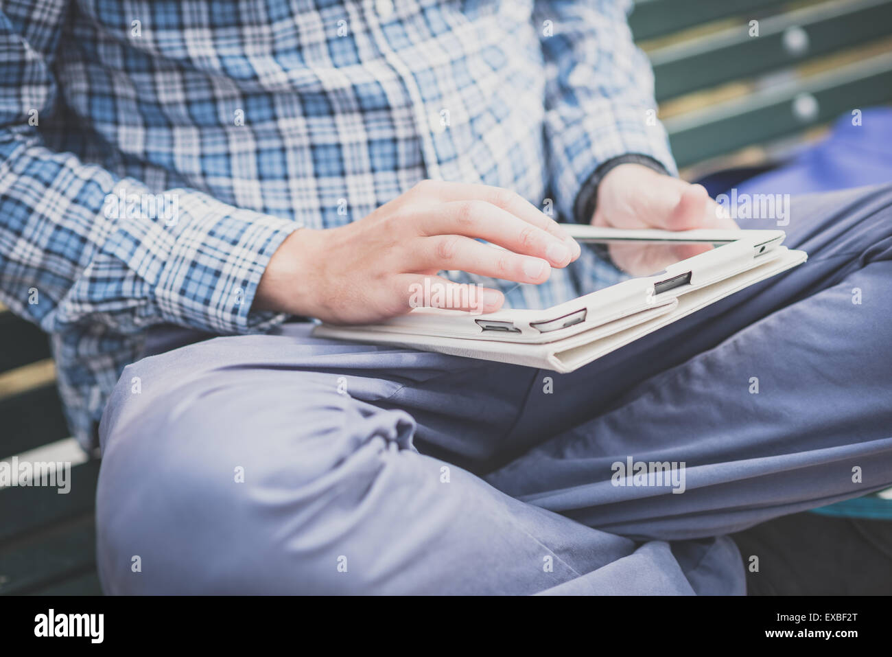 close up hands man using tablet on the bench Stock Photo - Alamy