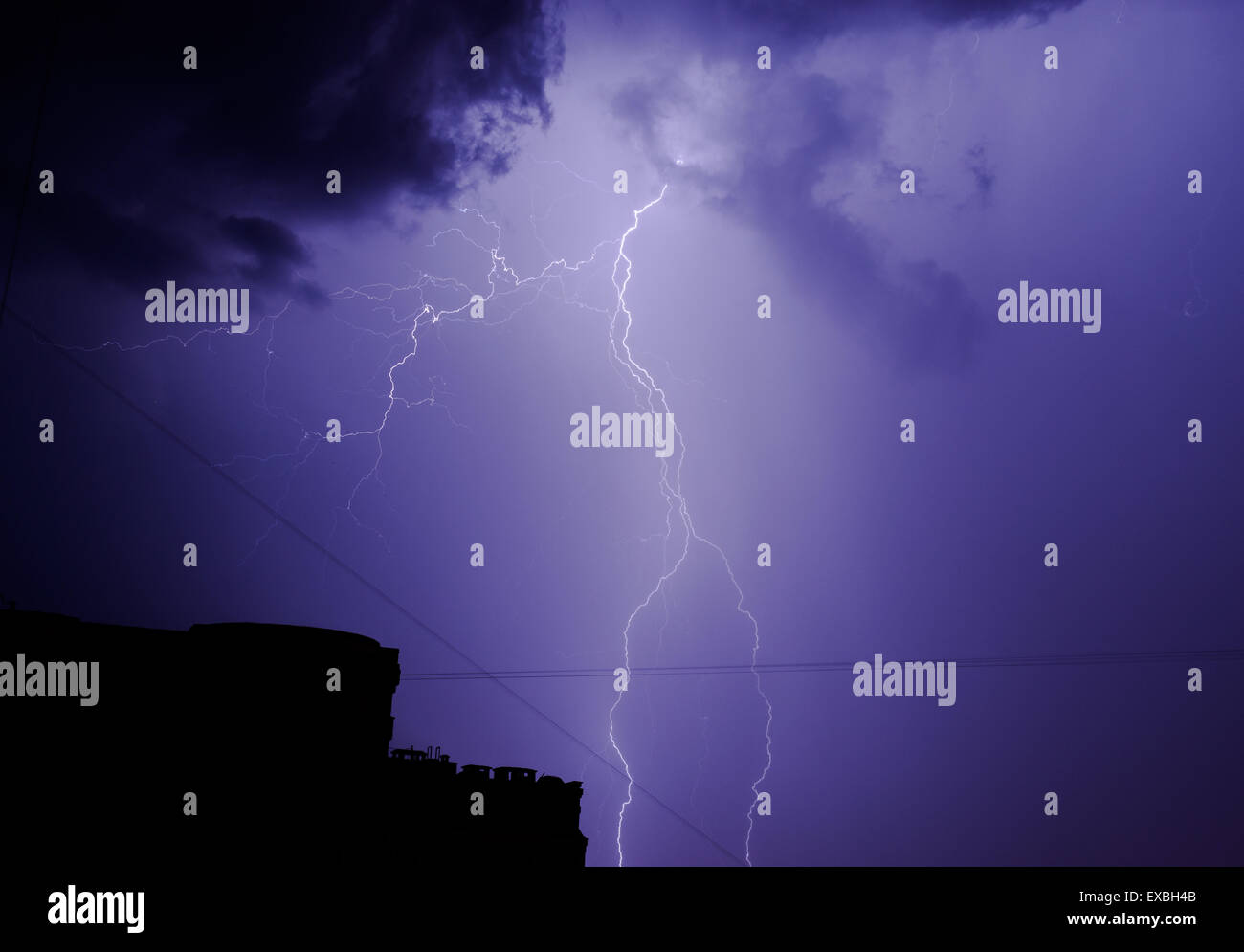 Bright lightning strike at night with thunder clouds overhead Stock ...