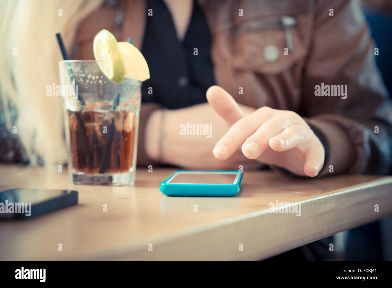 close up of woman hands using smart phones at the bar Stock Photo - Alamy