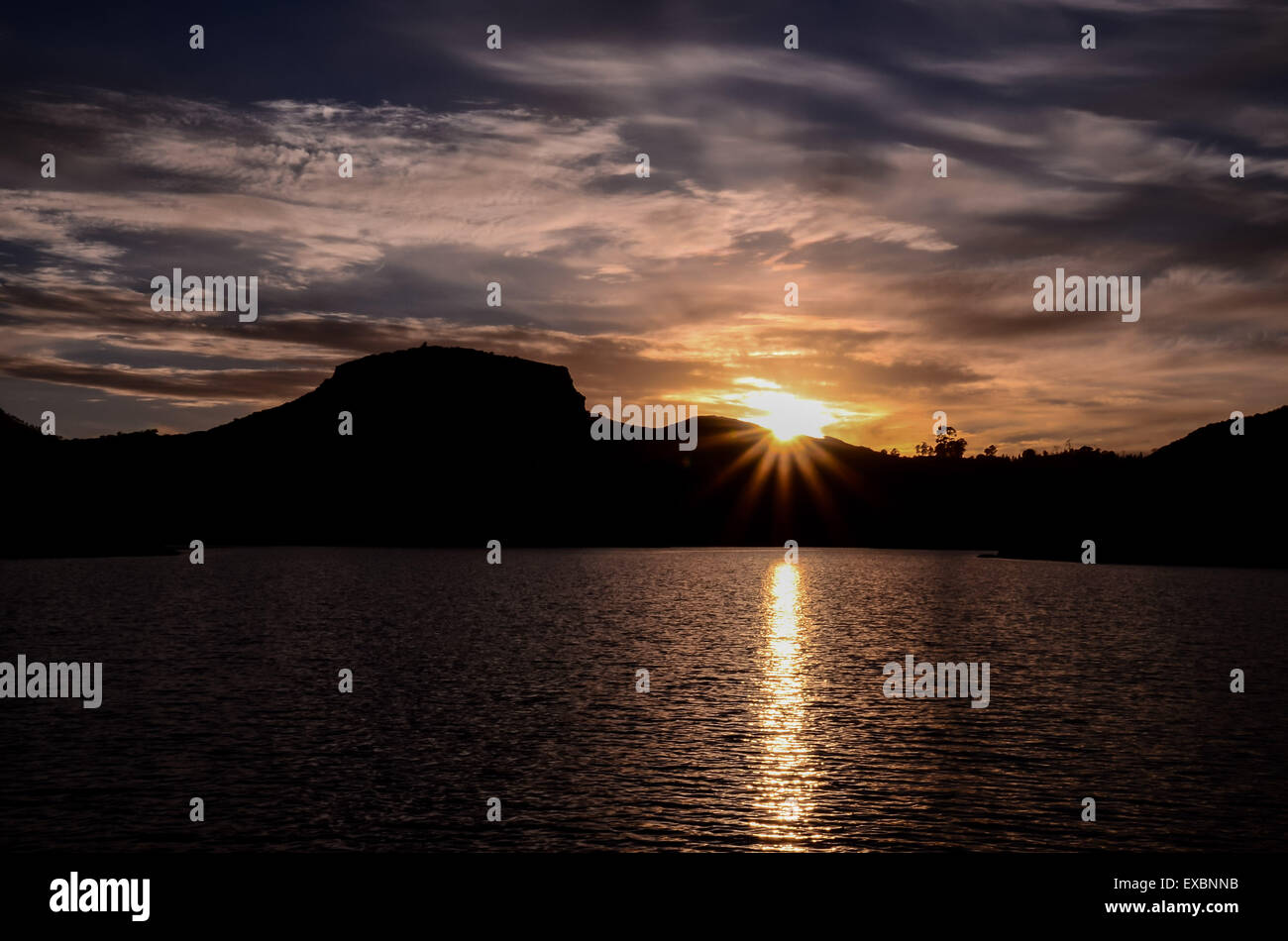 Sun behind a Mountain Silhouette Stock Photo - Alamy