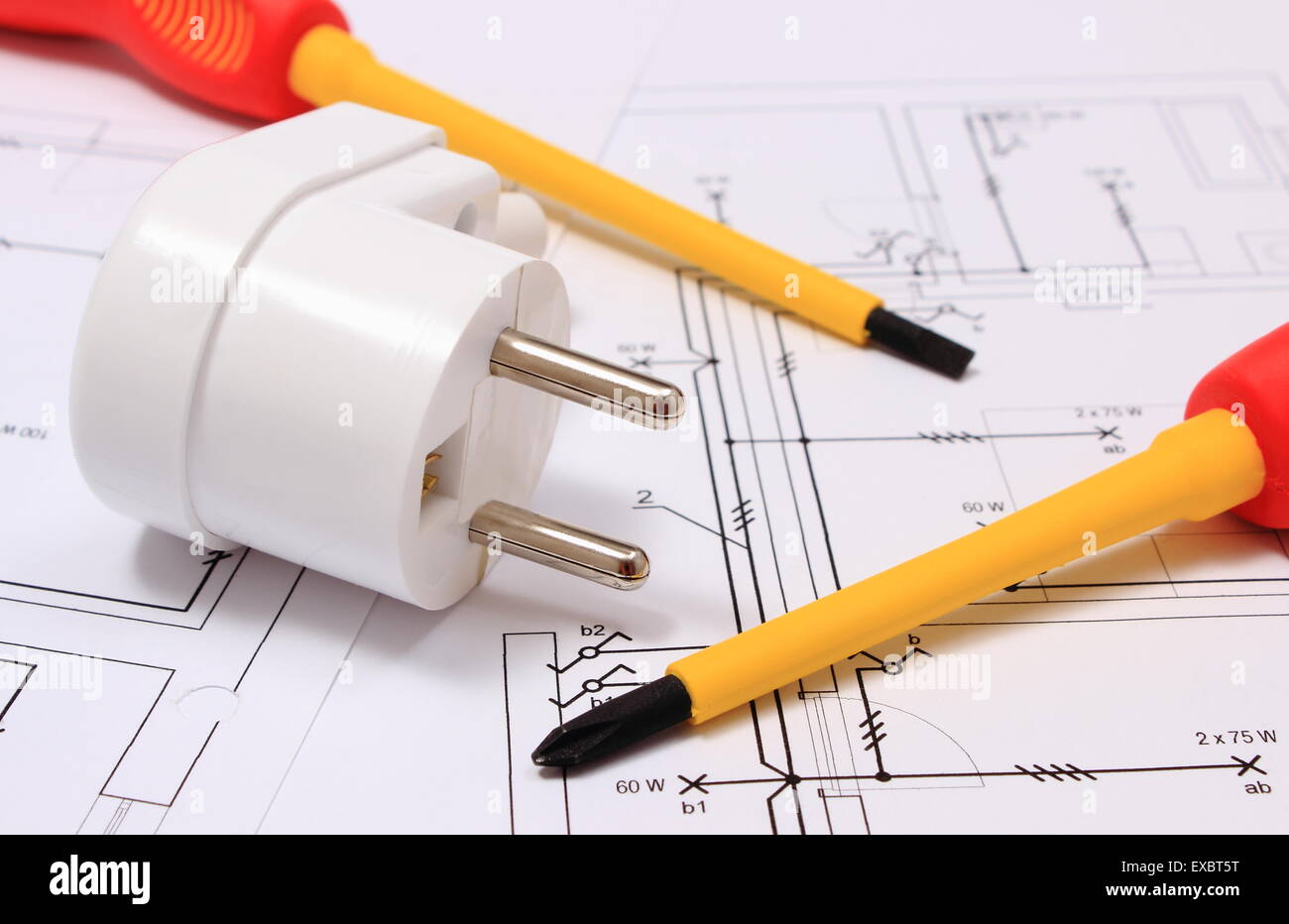 Screwdriver, work tools and electric plug lying on construction drawing ...
