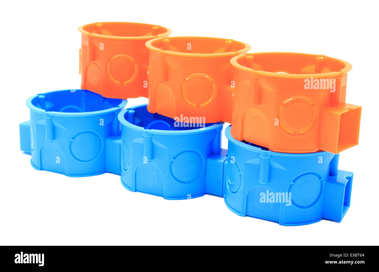 Stack of orange and blue plastic electrical boxes on white background ...