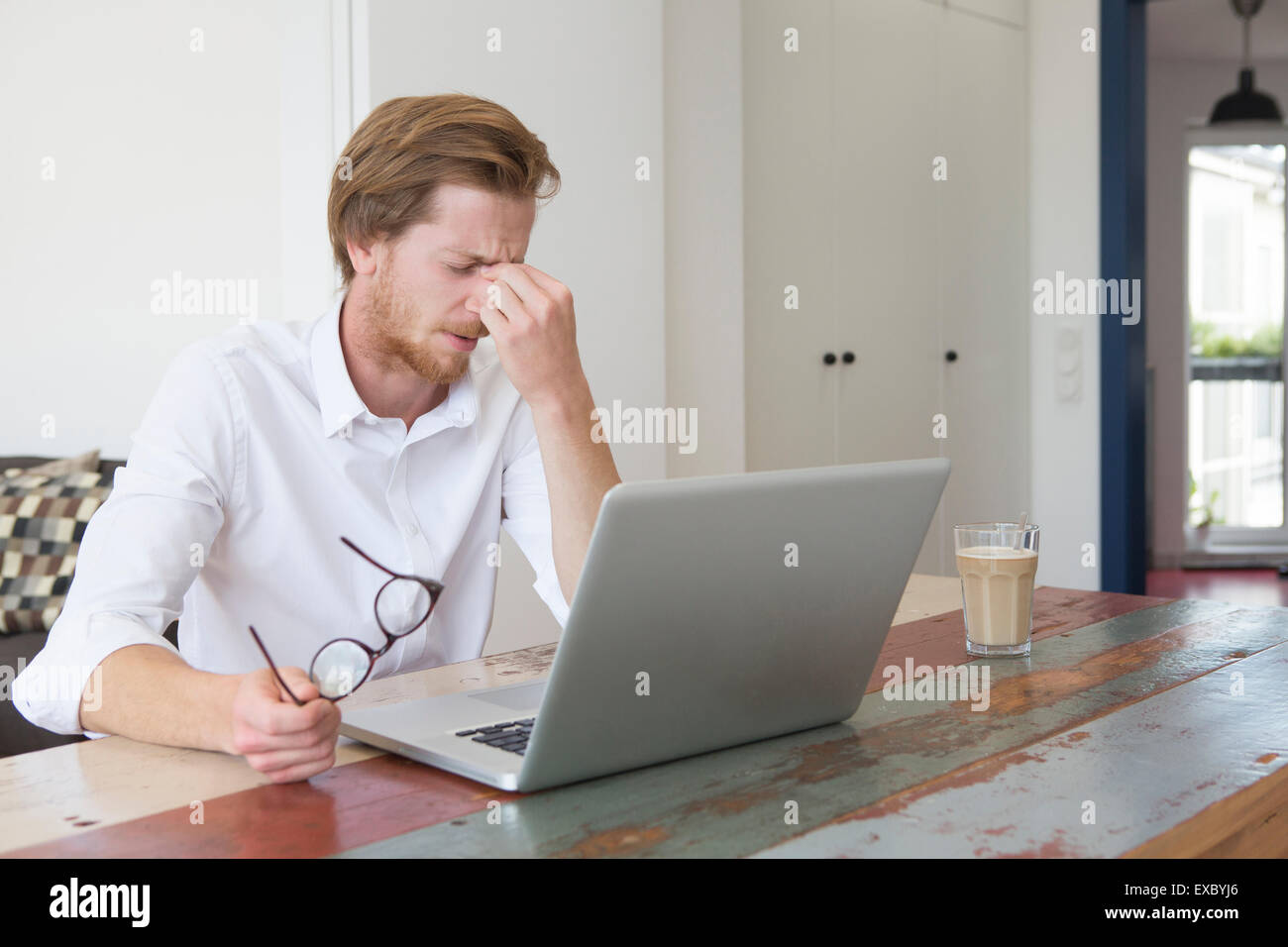 Young man headache sitting desk hi-res stock photography and images - Alamy