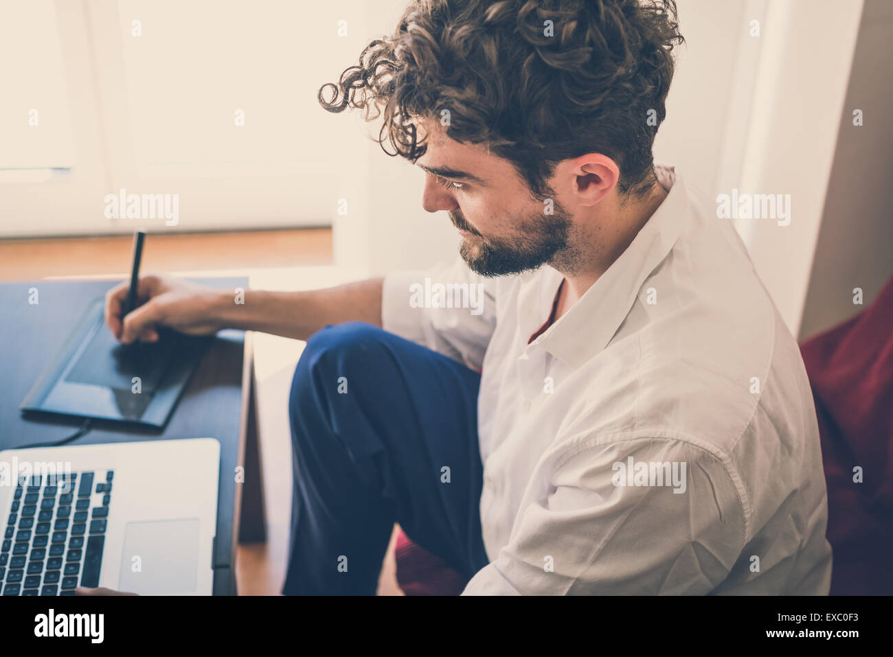 handsome hipster modern man designer working home using laptop at home ...