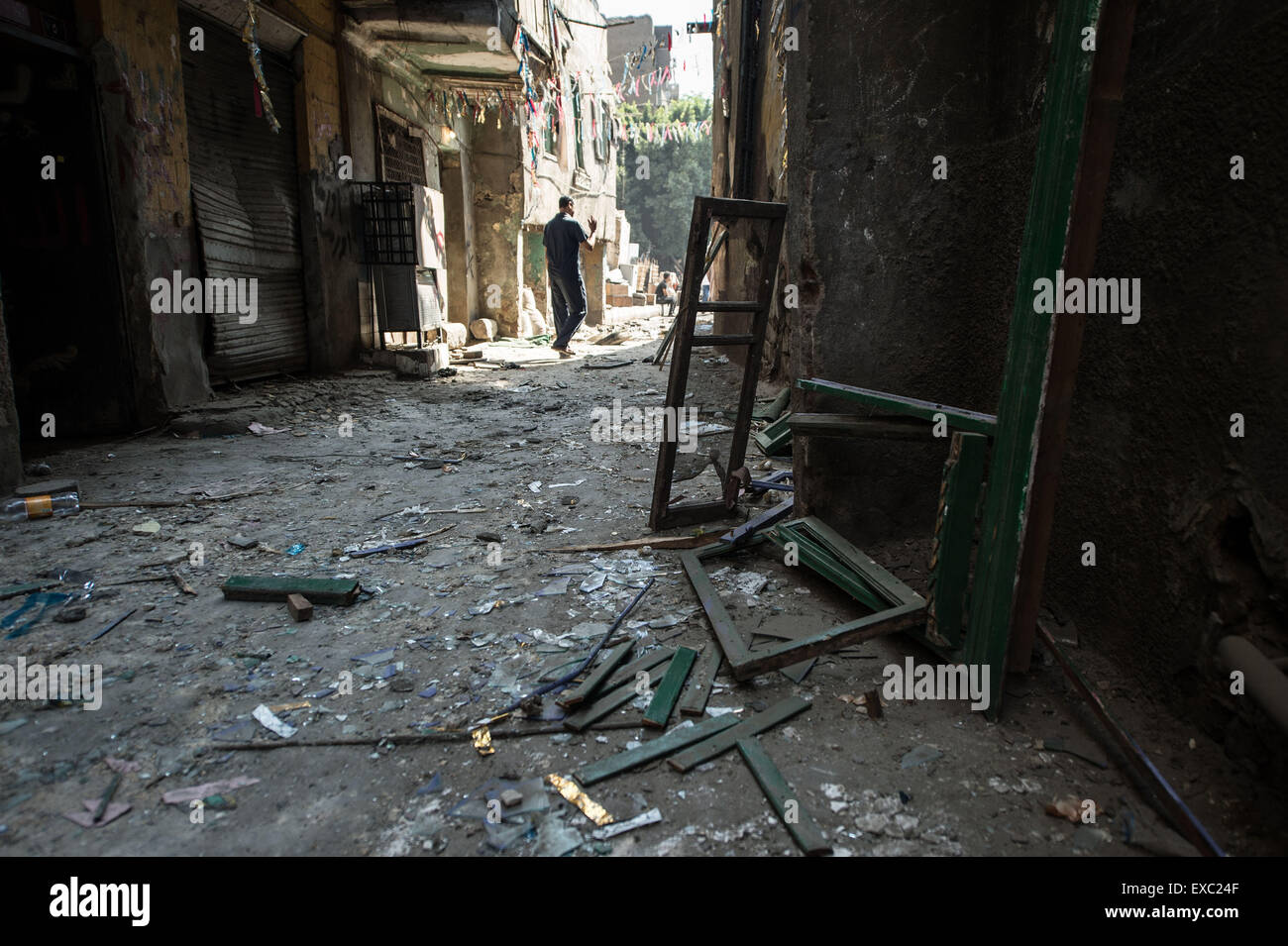 Cairo, Egypt. 11th July, 2015. An Egyptian walks by damaged buildings ...